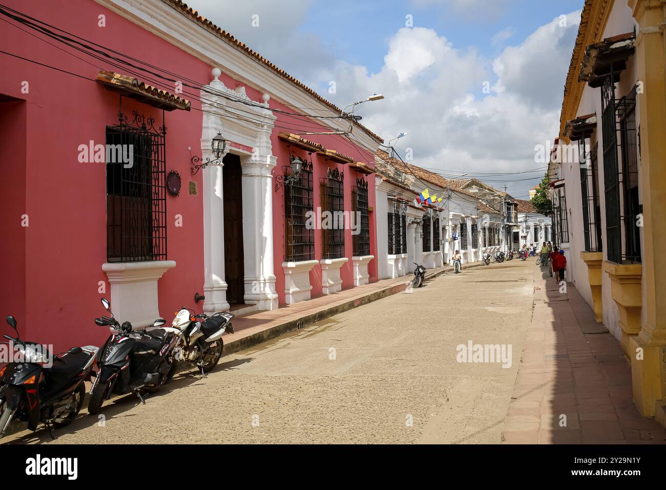 Typical street with colorful one story buildings in sun and shadow of ...