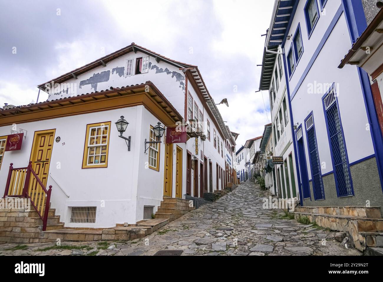 Typical steep cobblestone street with traditional houses in historic ...