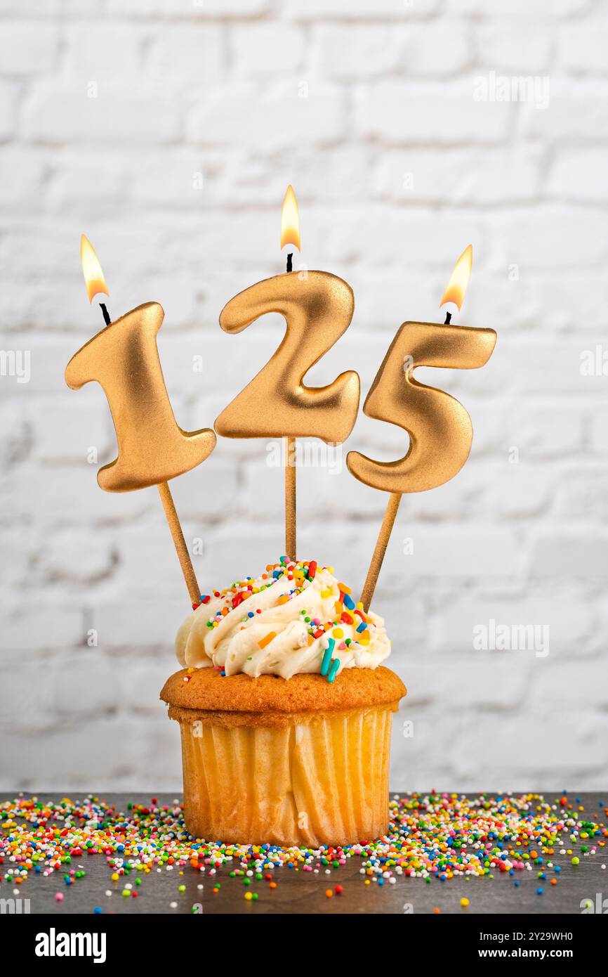 Golden birthday candle number 125 with cupcake - White block wall ...