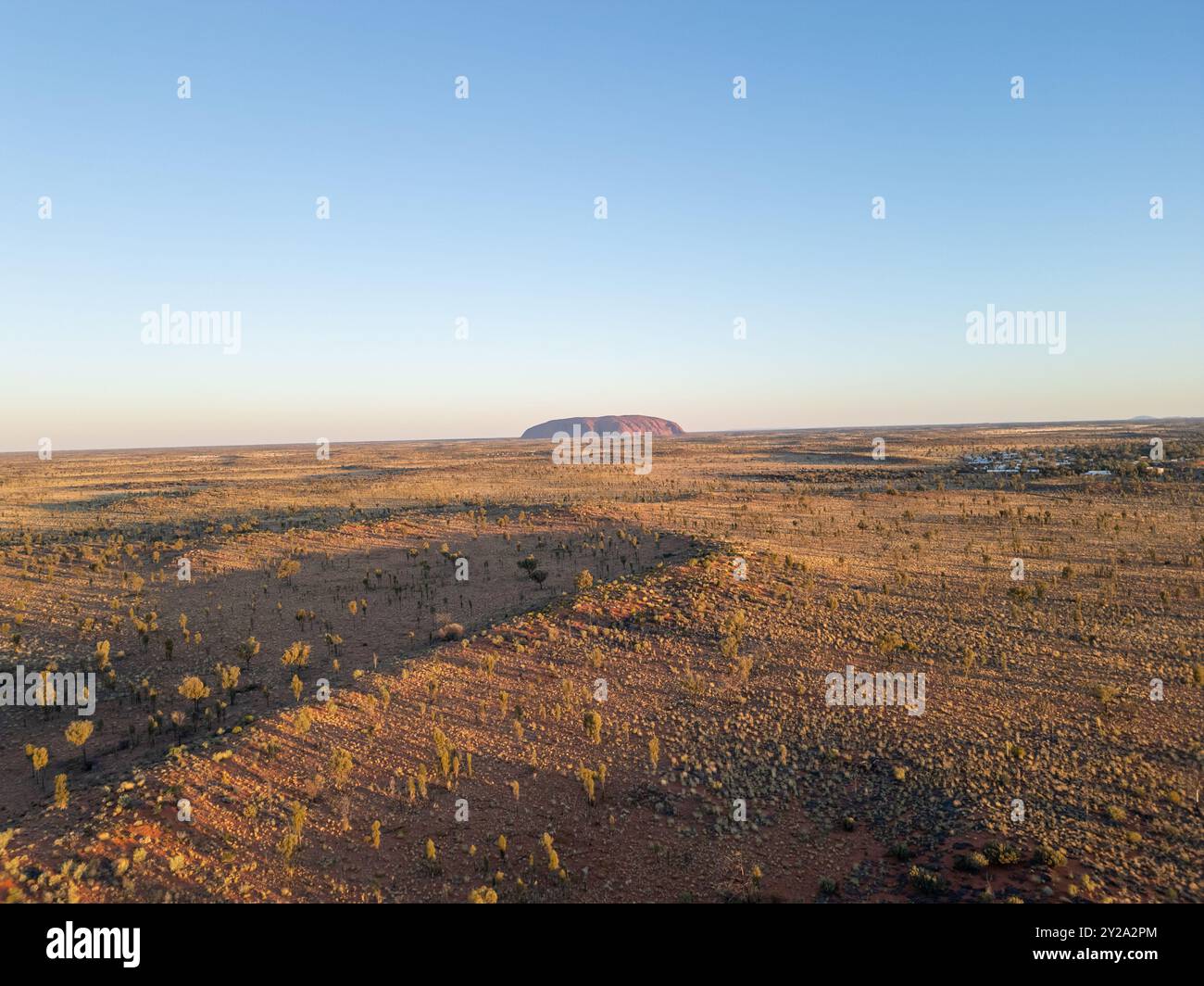 A breathtaking aerial view of Uluru Rock in Australia illuminated by a ...
