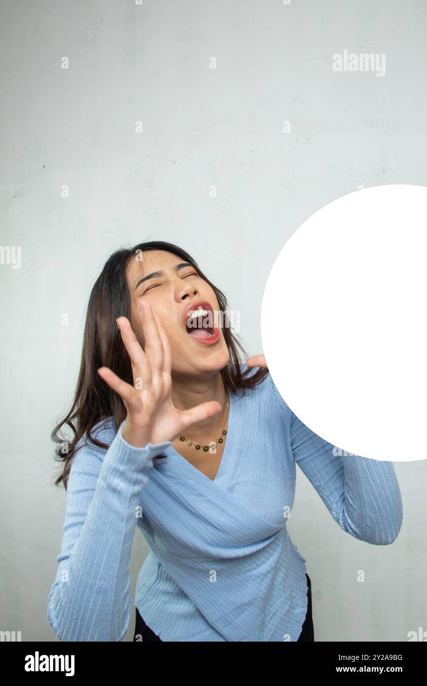 Close-up emotional expression of Asian woman standing bent forward ...
