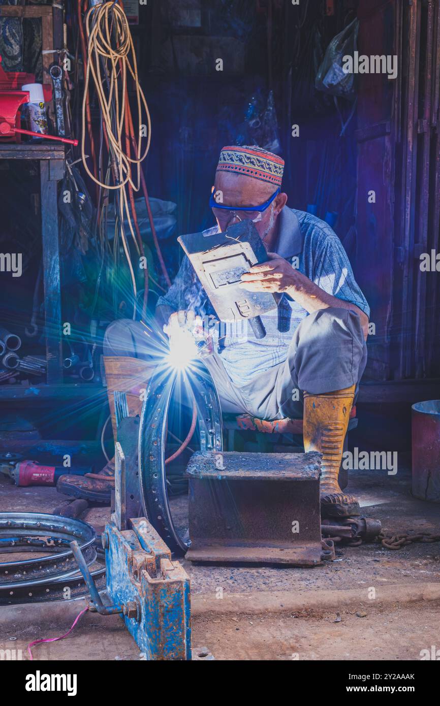 Balikpapan, Indonesia - June 26th, 2024. the the old welder is doing ...