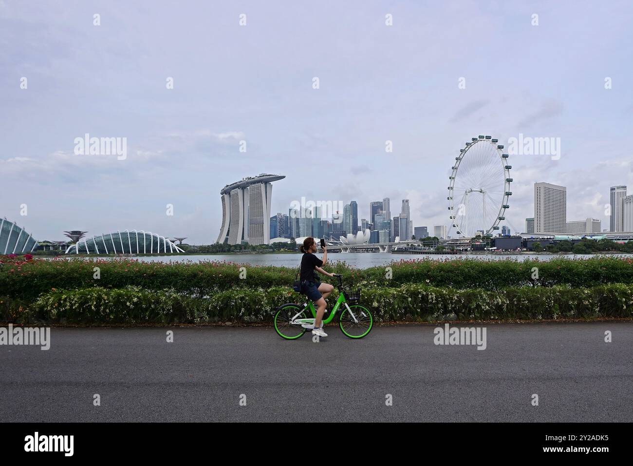 A cyclist takes photo of the city skyline in Singapore, Sunday, Sept. 8 ...