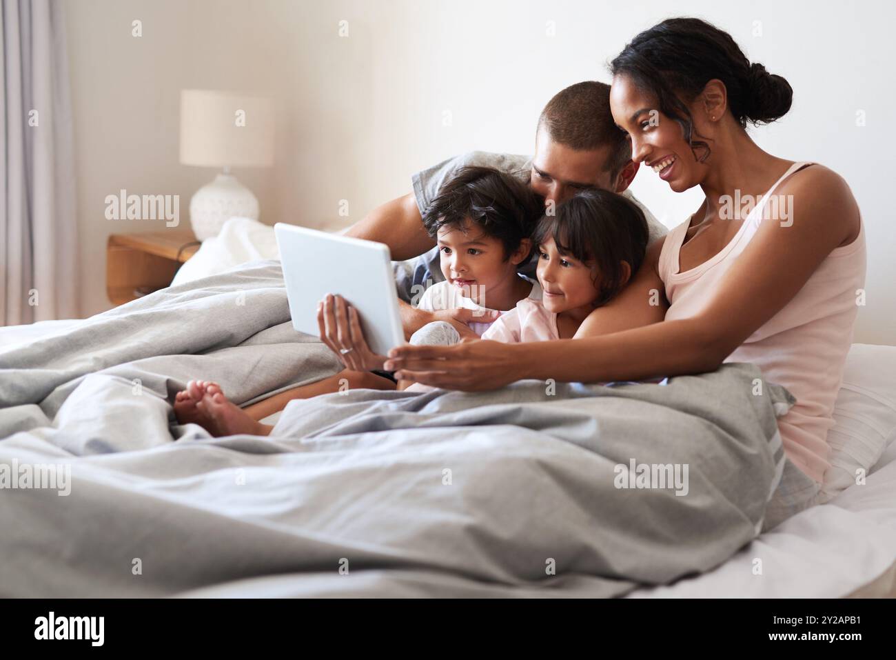 Family, happy and tablet on bed for bonding, relax and streaming ...