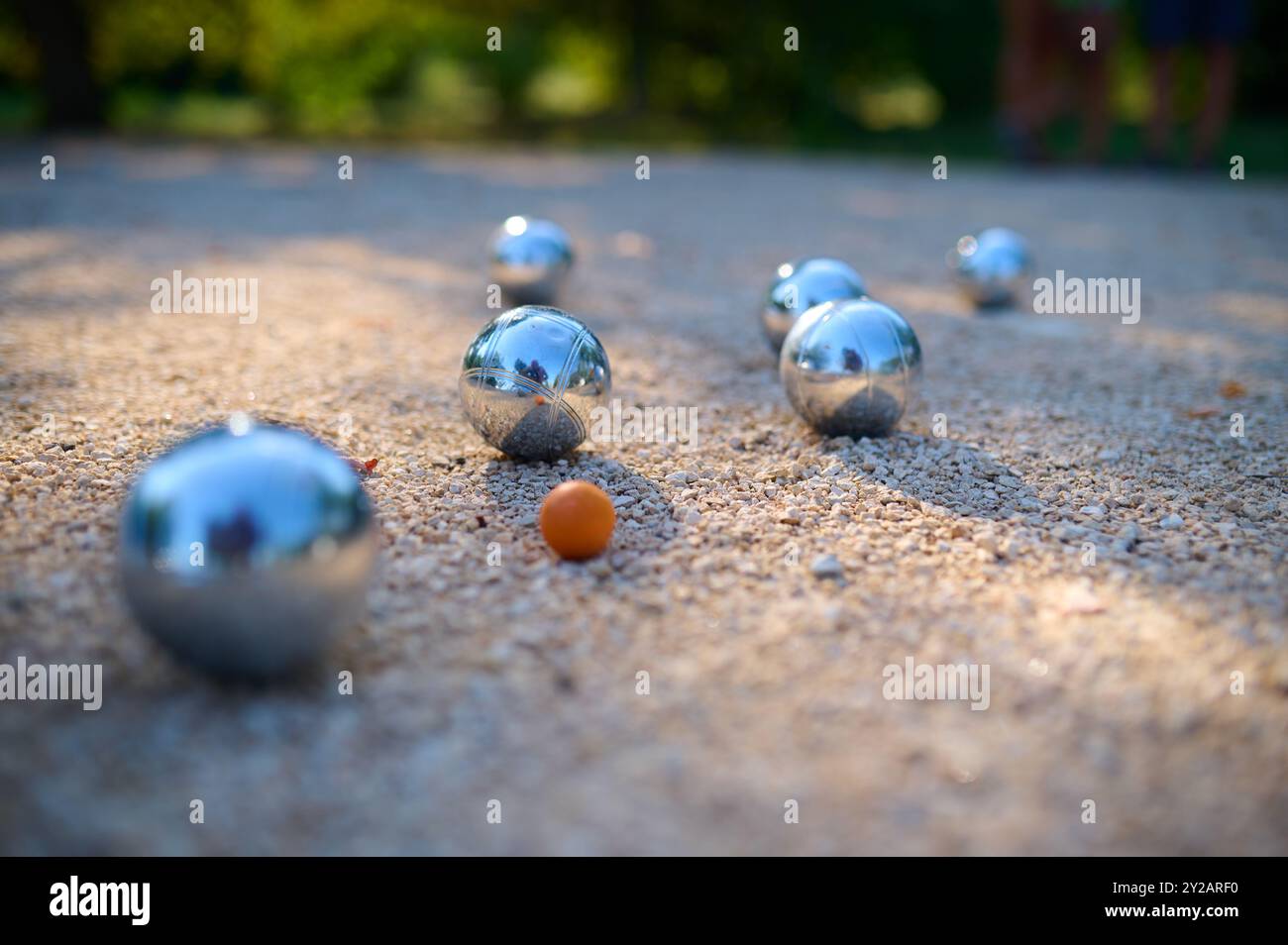 Close-up of petanque balls scattered on gravel with the target ball in ...