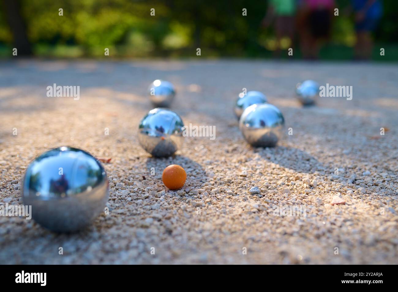 Close-up of petanque balls scattered on gravel with the target ball in ...