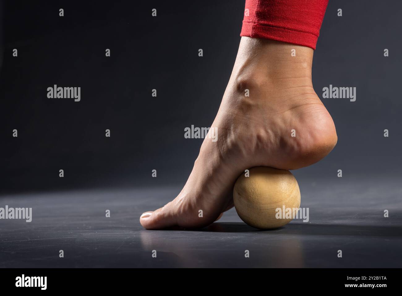 Myofascial release of foot muscles with a massage ball on a dark ...