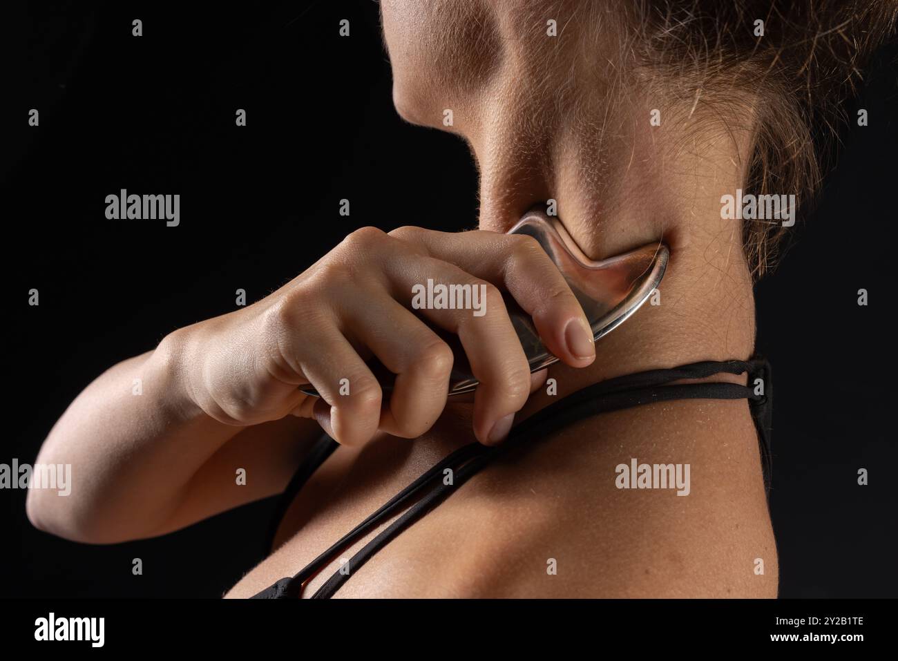 woman uses metal tool for massage and soft tissue mobilization ...
