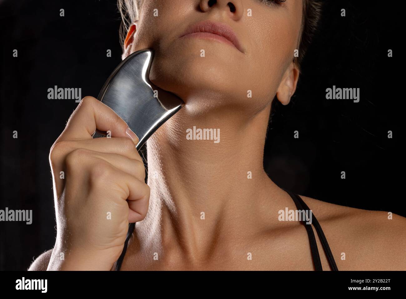 woman uses metal tool for massage and soft tissue mobilization ...