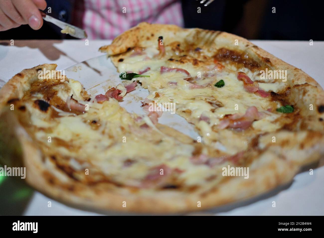 Cutting into two halves a pizza at Pizza At Napule E’ Lago In Como ...