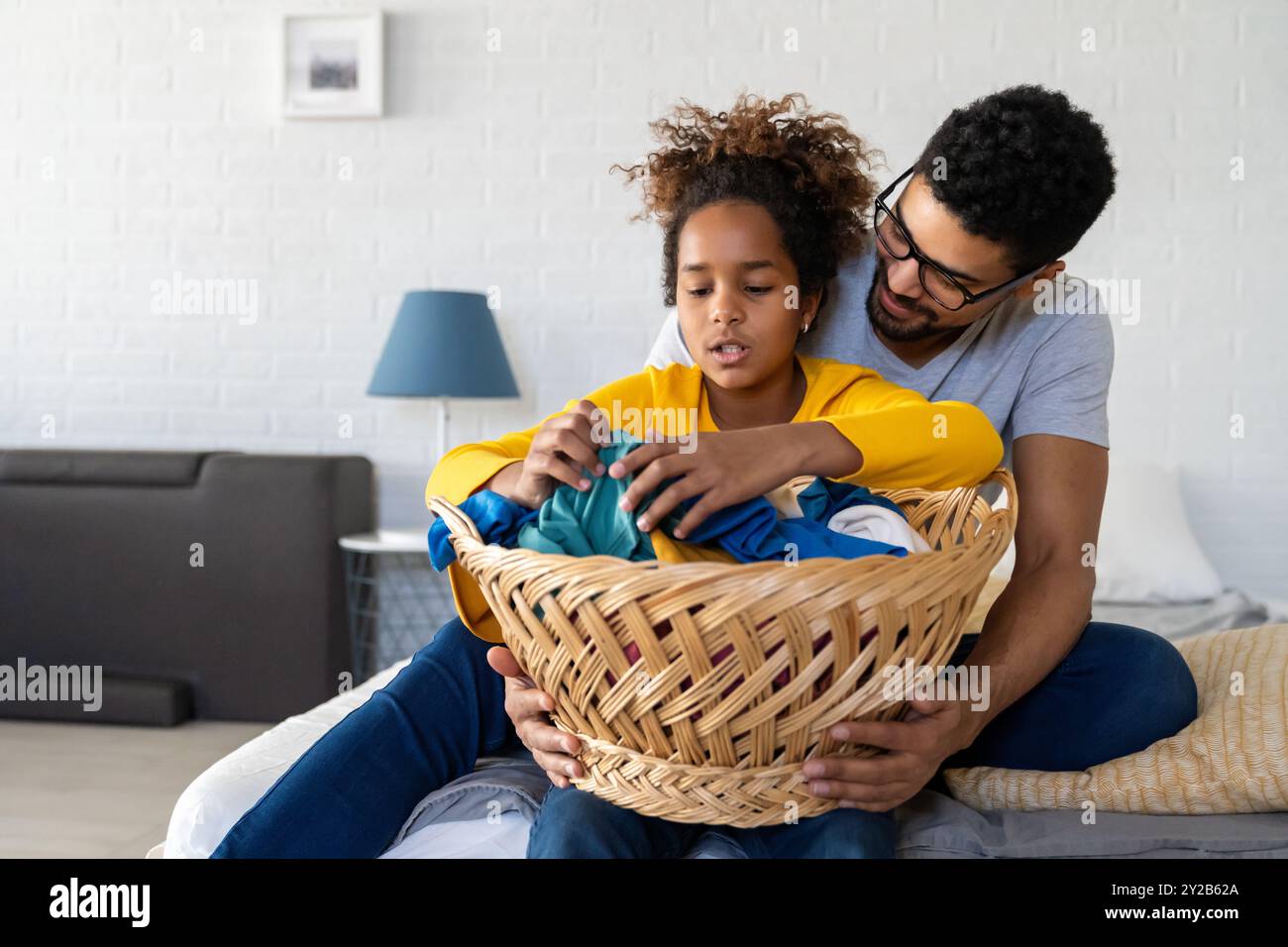 Black daughter helping father do household and domestic chores together ...
