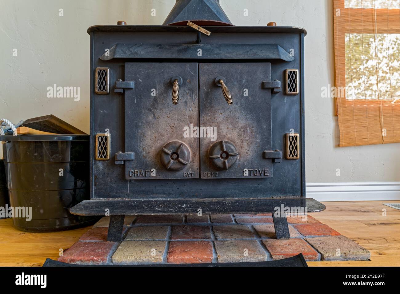 An antique iron wood burning Craft Stove sits on a brick platform Stock ...