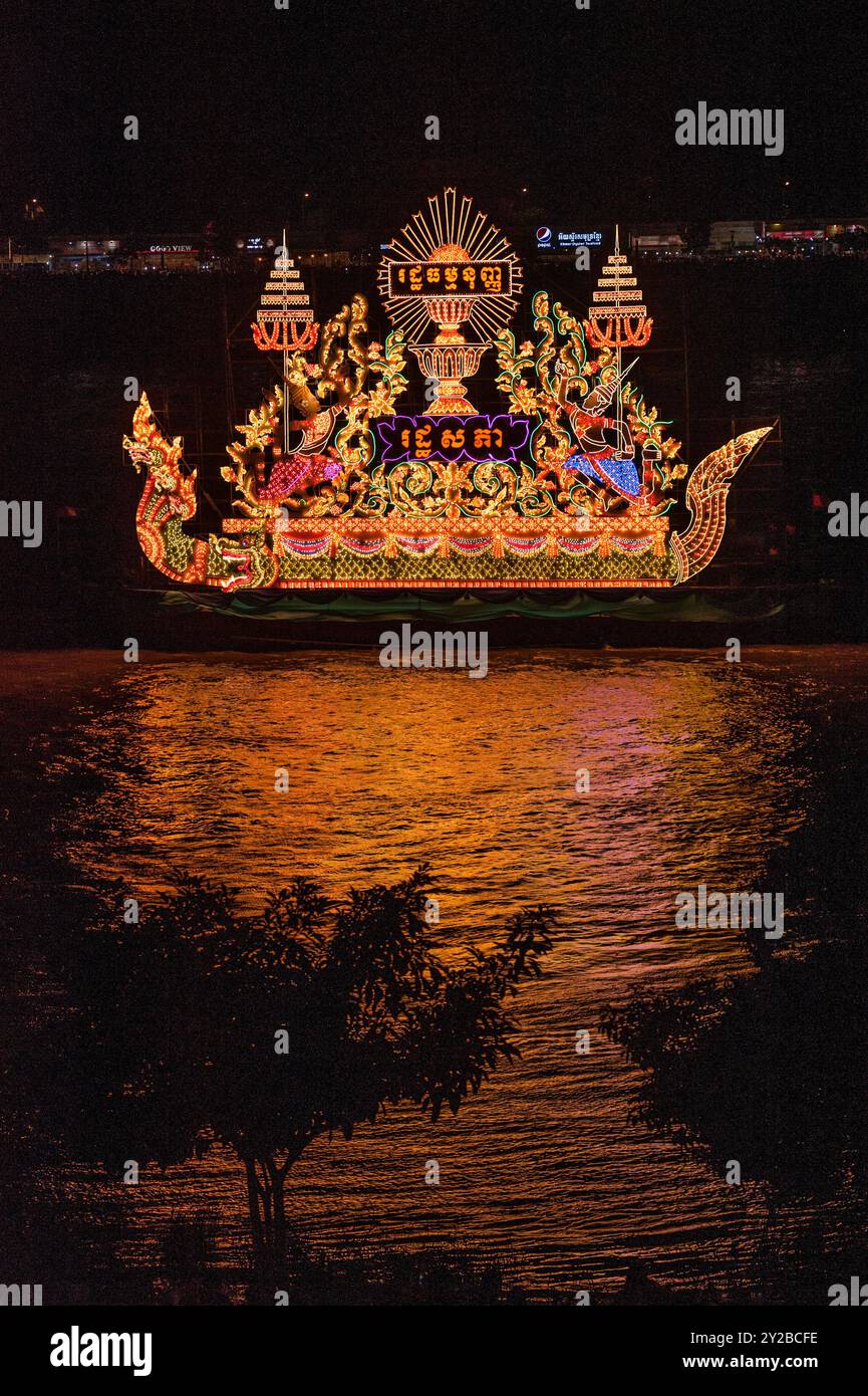 an Illuminated float / barge casts its reflection on the Tonle Sap ...