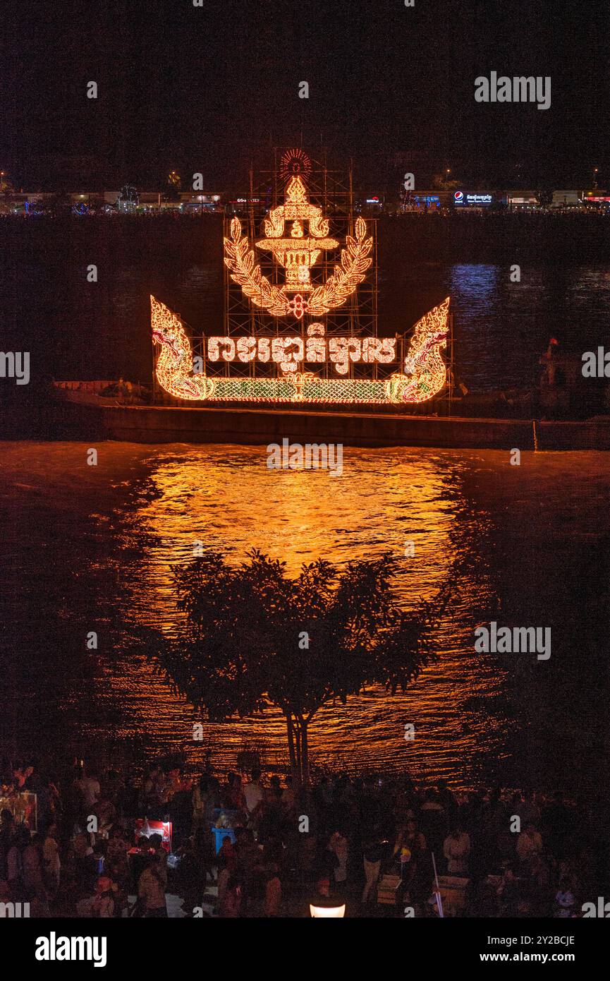 an Illuminated float / barge casts its reflection on the Tonle Sap ...