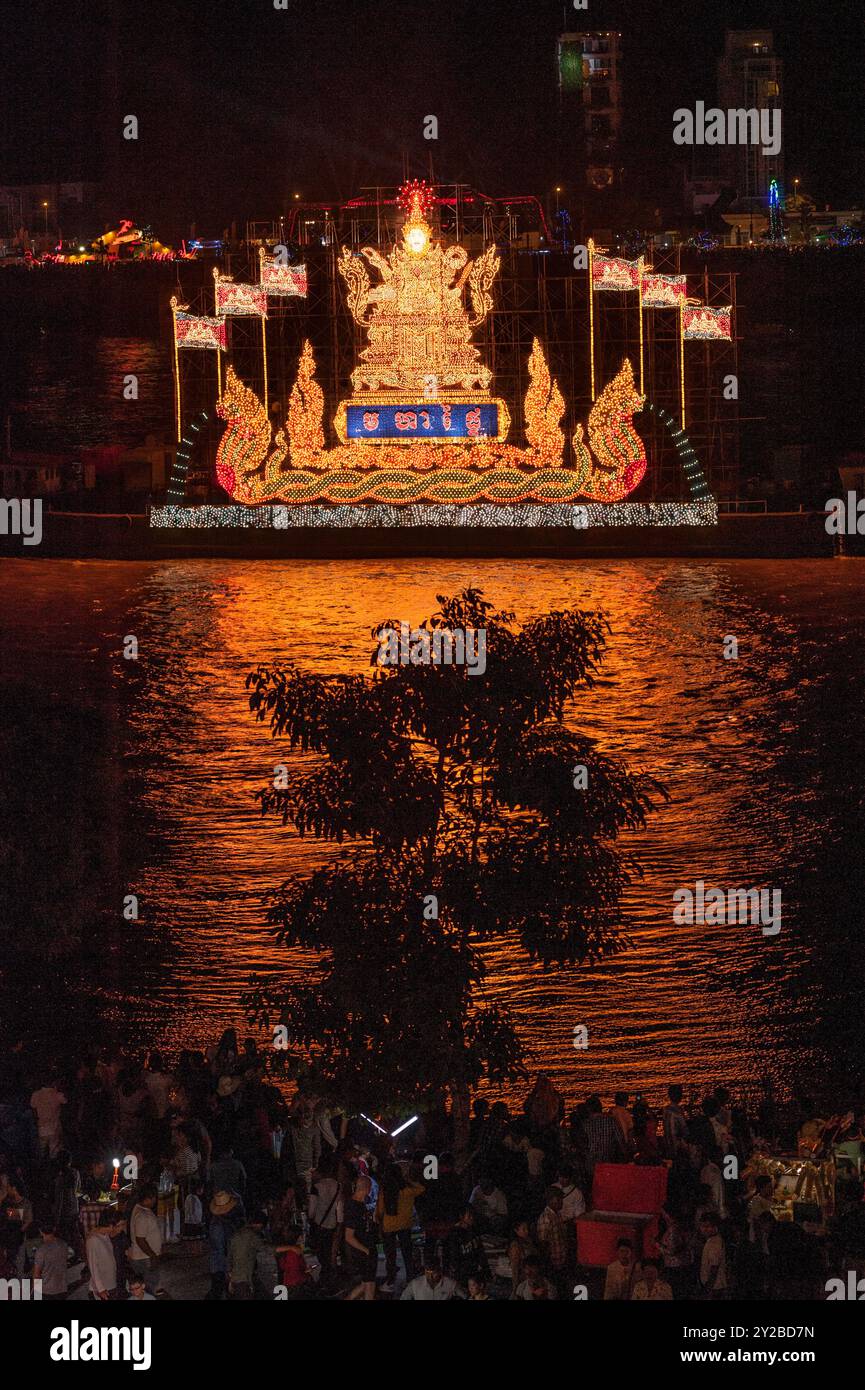 an Illuminated float / barge casts its reflection on the Tonle Sap ...