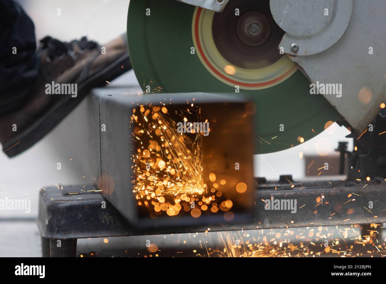 Worker cutting steel rectangular pipe in construction site Stock Photo ...