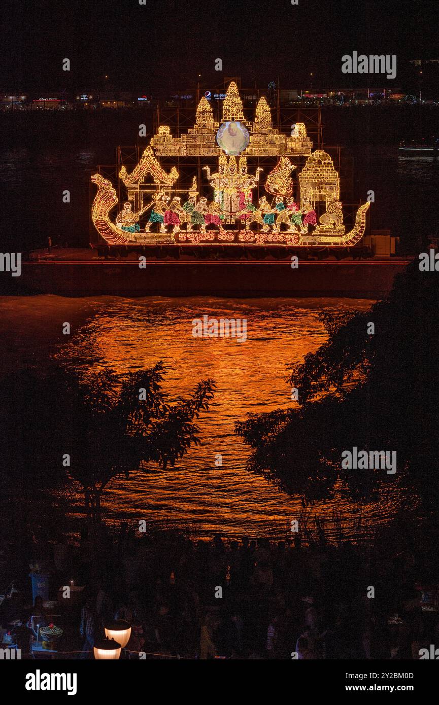 an Illuminated float / barge casts its reflection on the Tonle Sap ...