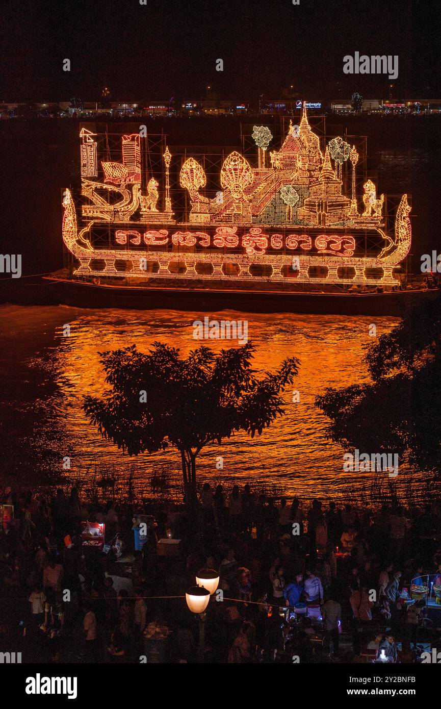 an Illuminated float / barge casts its reflection on the Tonle Sap ...
