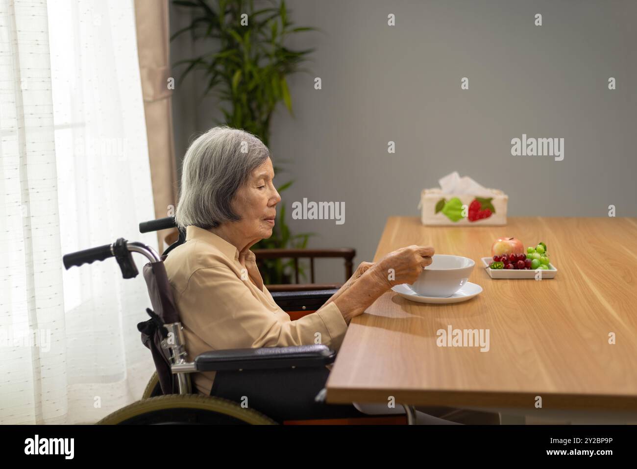 Lonely senior asian woman bored with food Stock Photo - Alamy