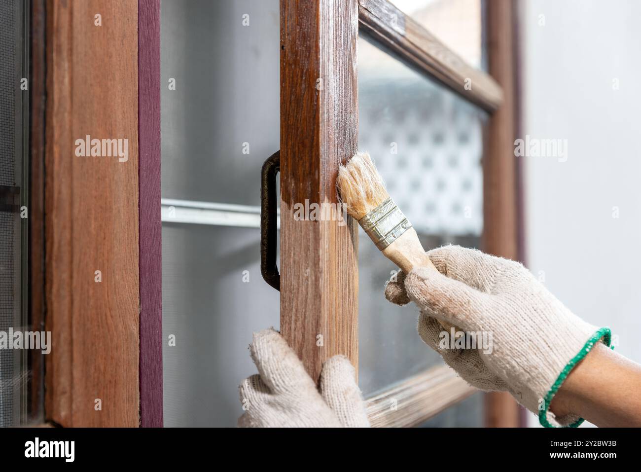 Worker use brush apply wood preserver after sandling the old surface of ...