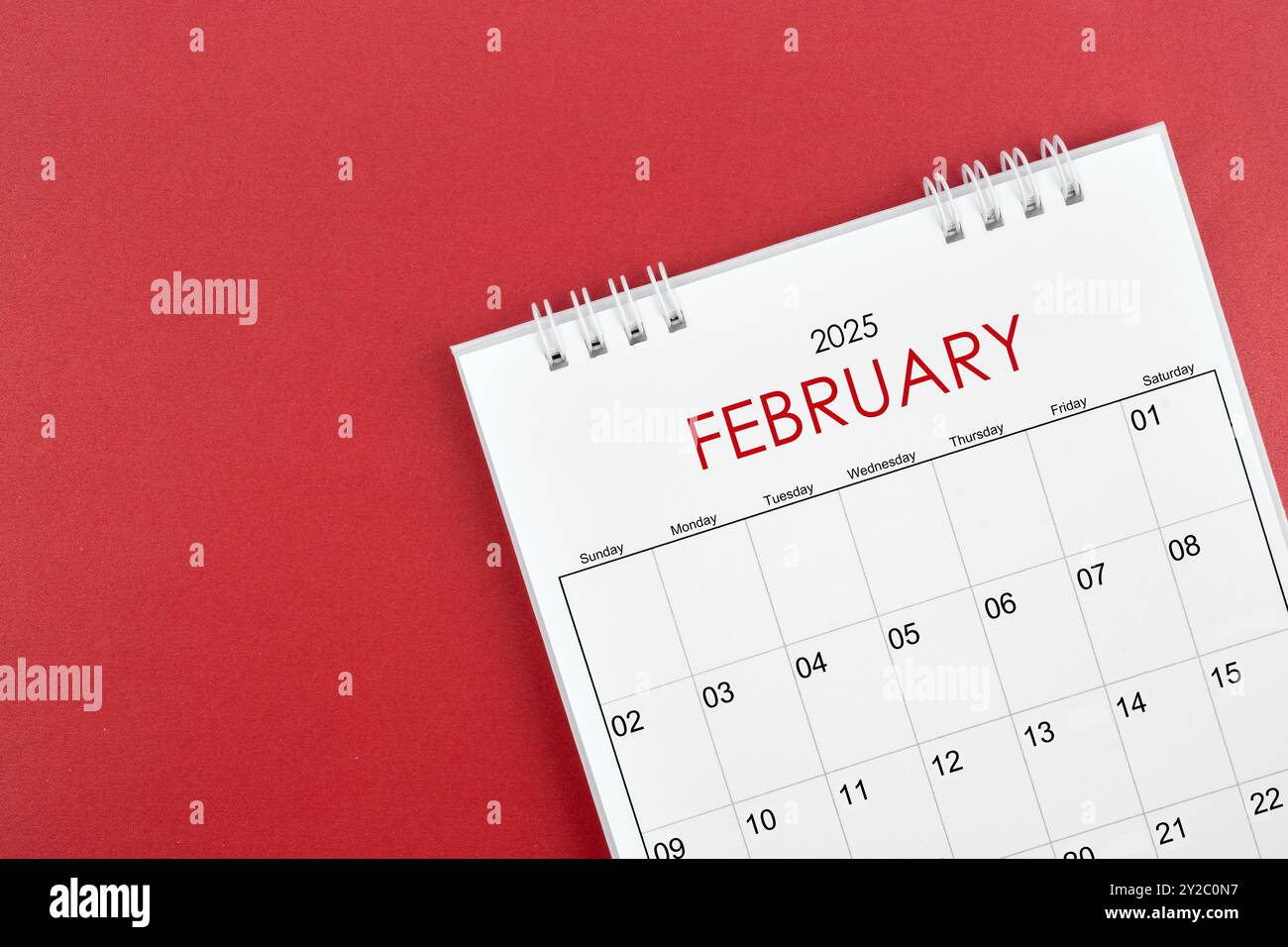 February 2025 desk calendar on red color background Stock Photo - Alamy