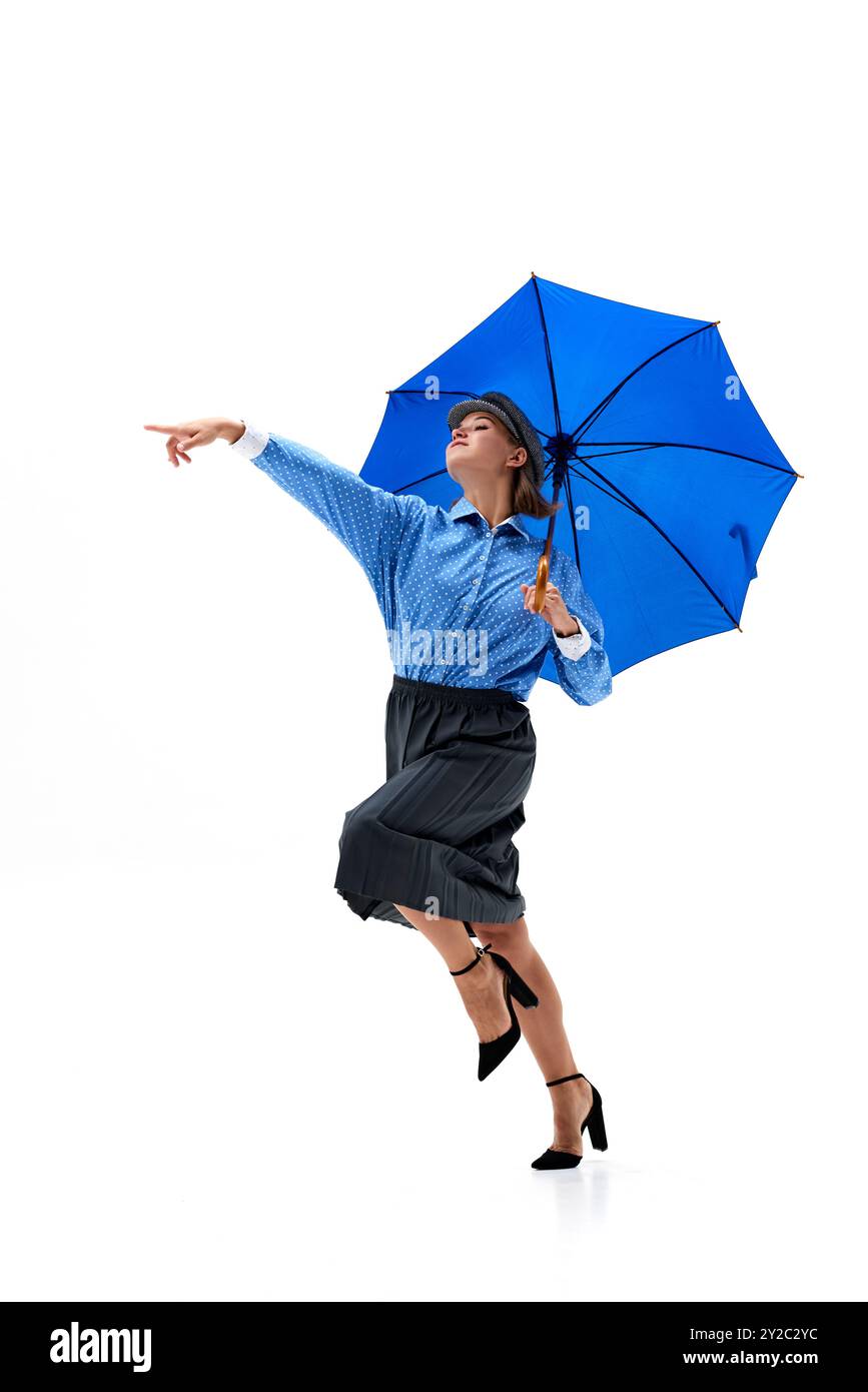 Stylish woman, dressed retro outfit, leaps with blue umbrella ...