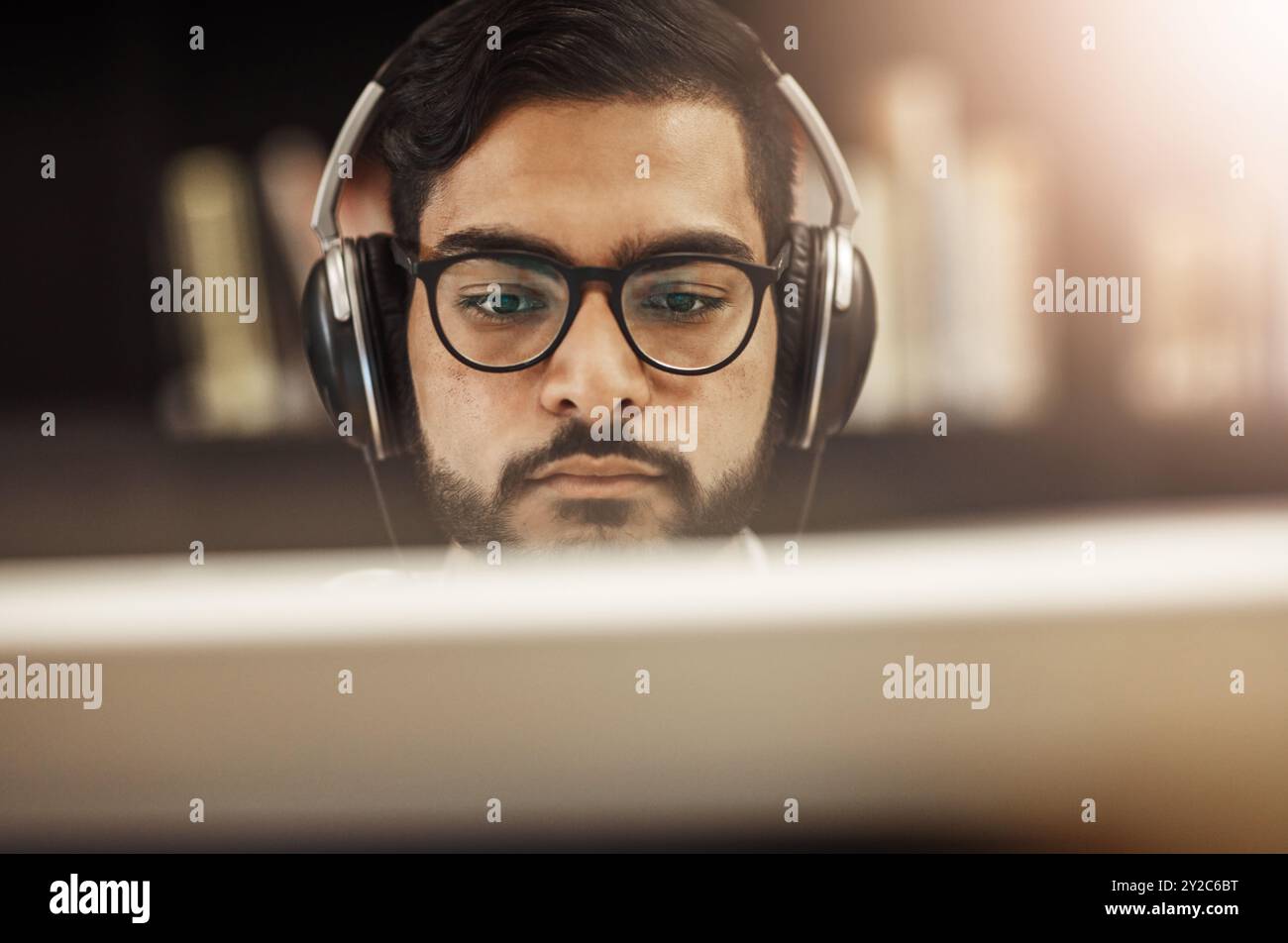 Computer, thinking and Indian man in library with headphones for ...