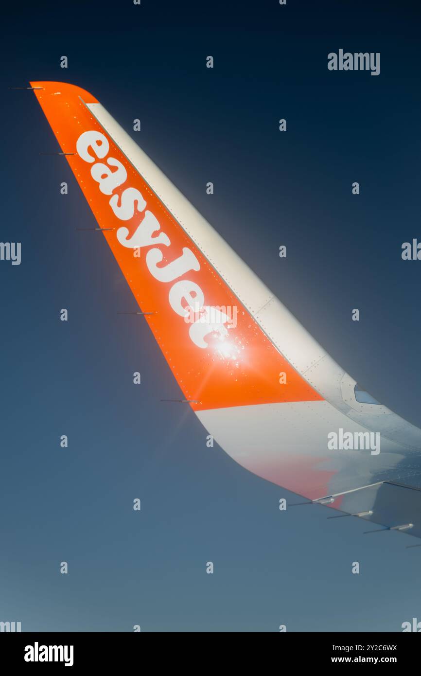 Easyjet plane wing, in flight blue sky with name on plane fin / wing ...