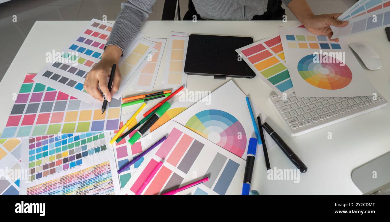 Graphic designer organizing color swatches on desk Stock Photo - Alamy