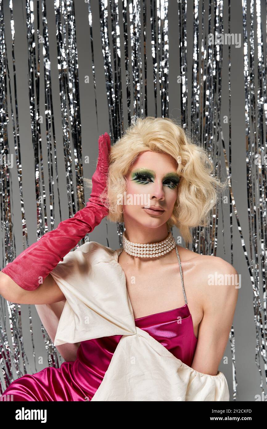 A vibrant young drag queen showcases a bold look in a shimmering ...