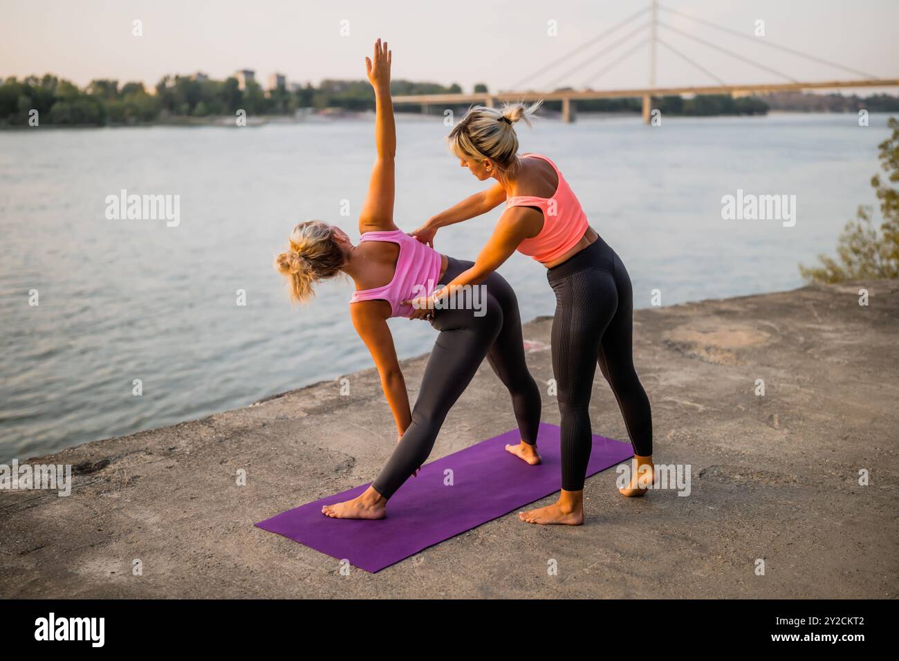Woman is practicing yoga with her instructor. Trikonasana, Bikram ...