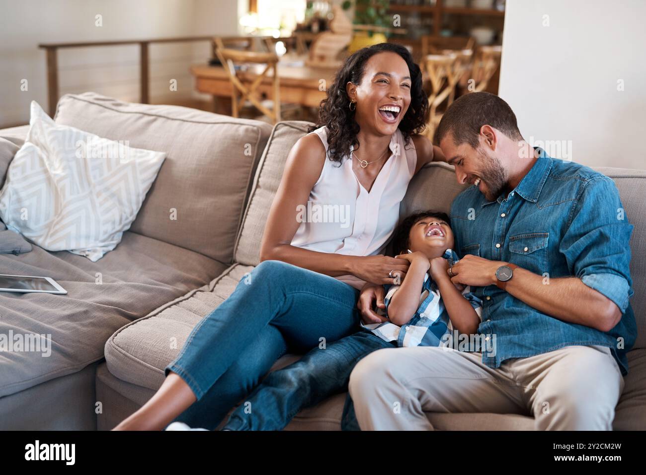 Family, laughing and tickle child in home, funny games and goofy bonding for love connection ...