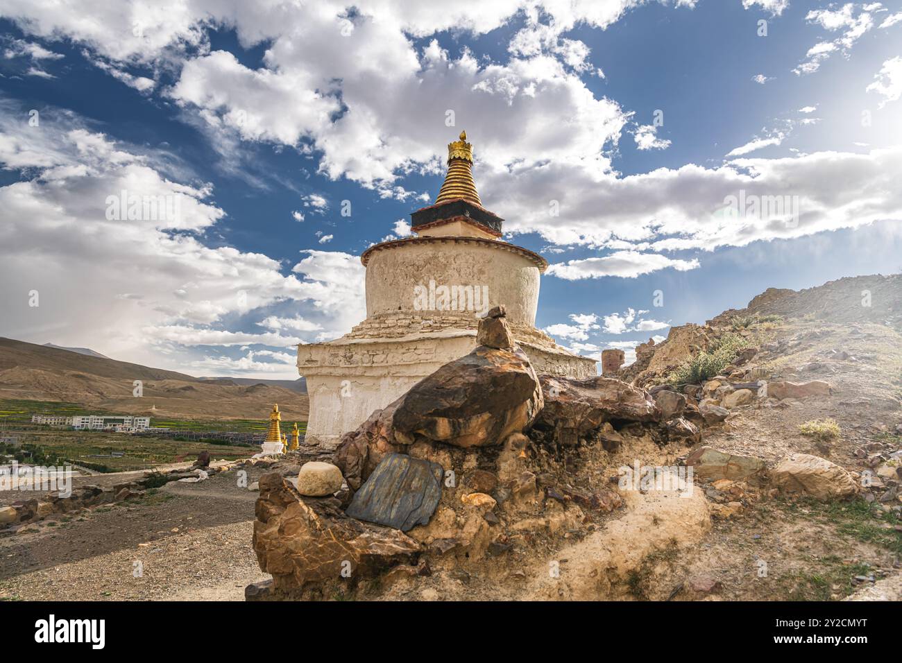 White stupa with golden top and part of the the buddhist Sakya ...