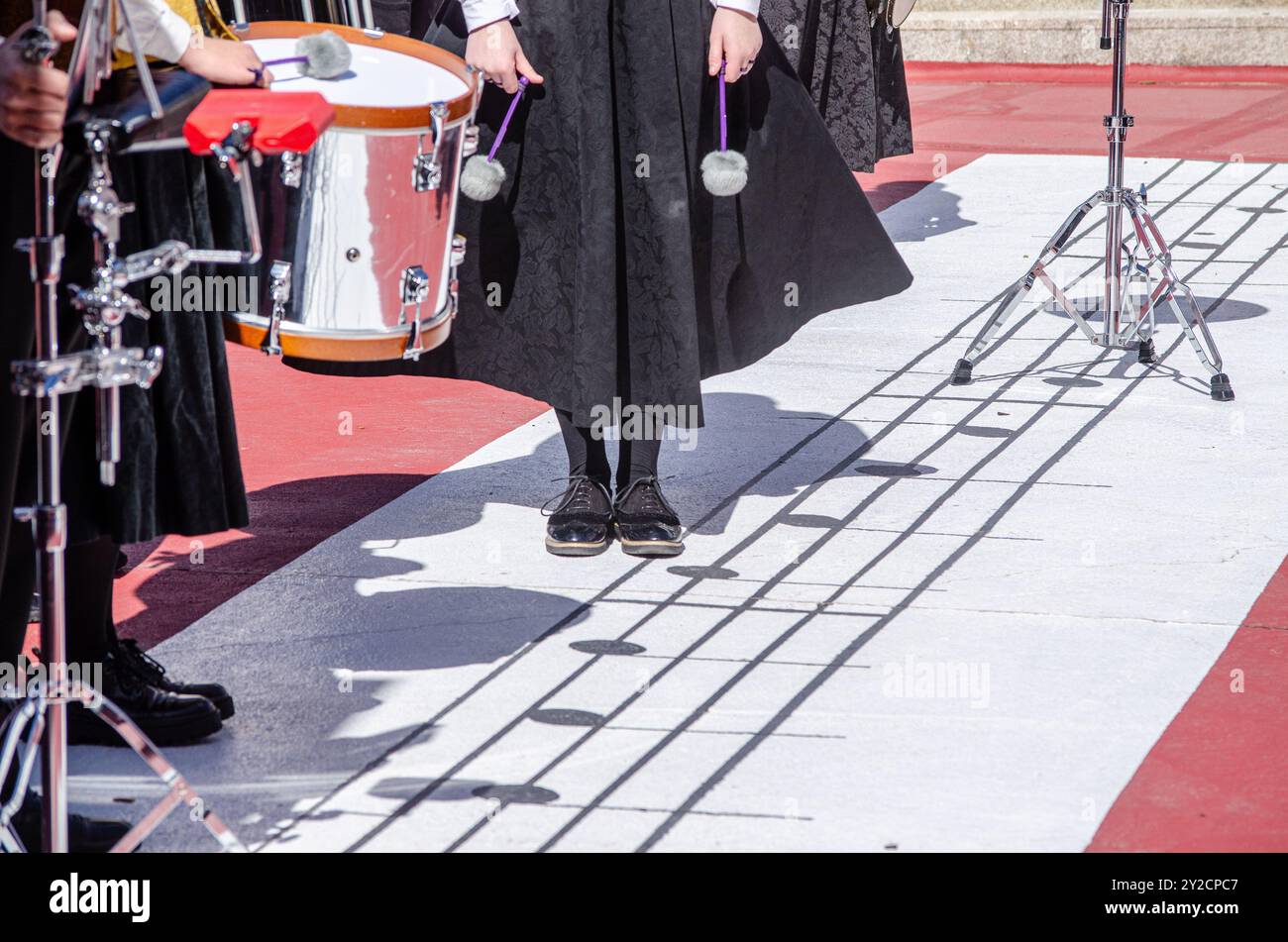 legs of a young woman musician playing the bass drum in a traditional ...