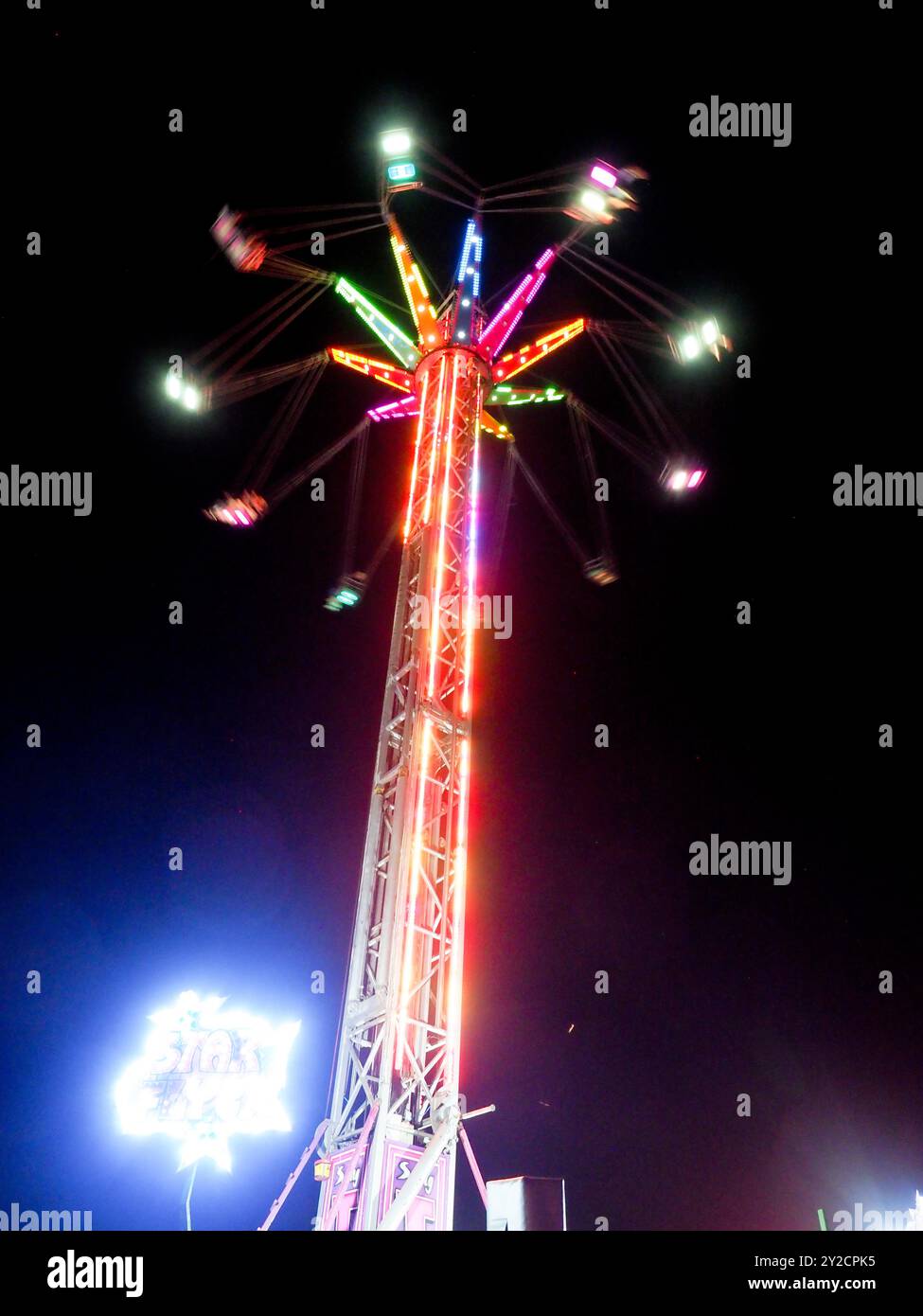 A modern fairground ride at night with neon lights Stock Photo - Alamy