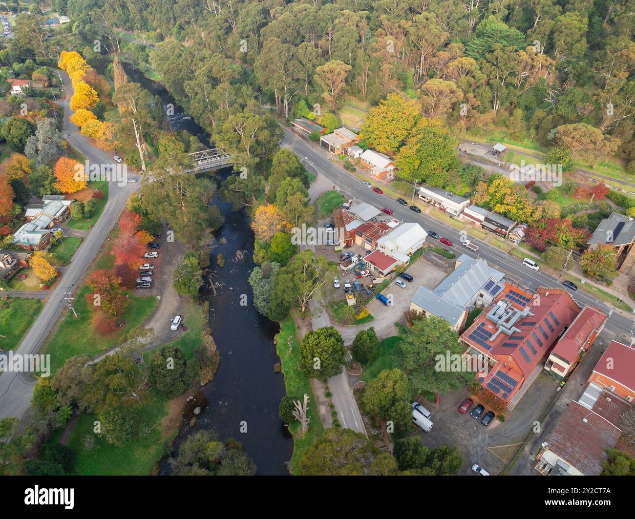 Aerial view of a small country town alongside a river with golden ...