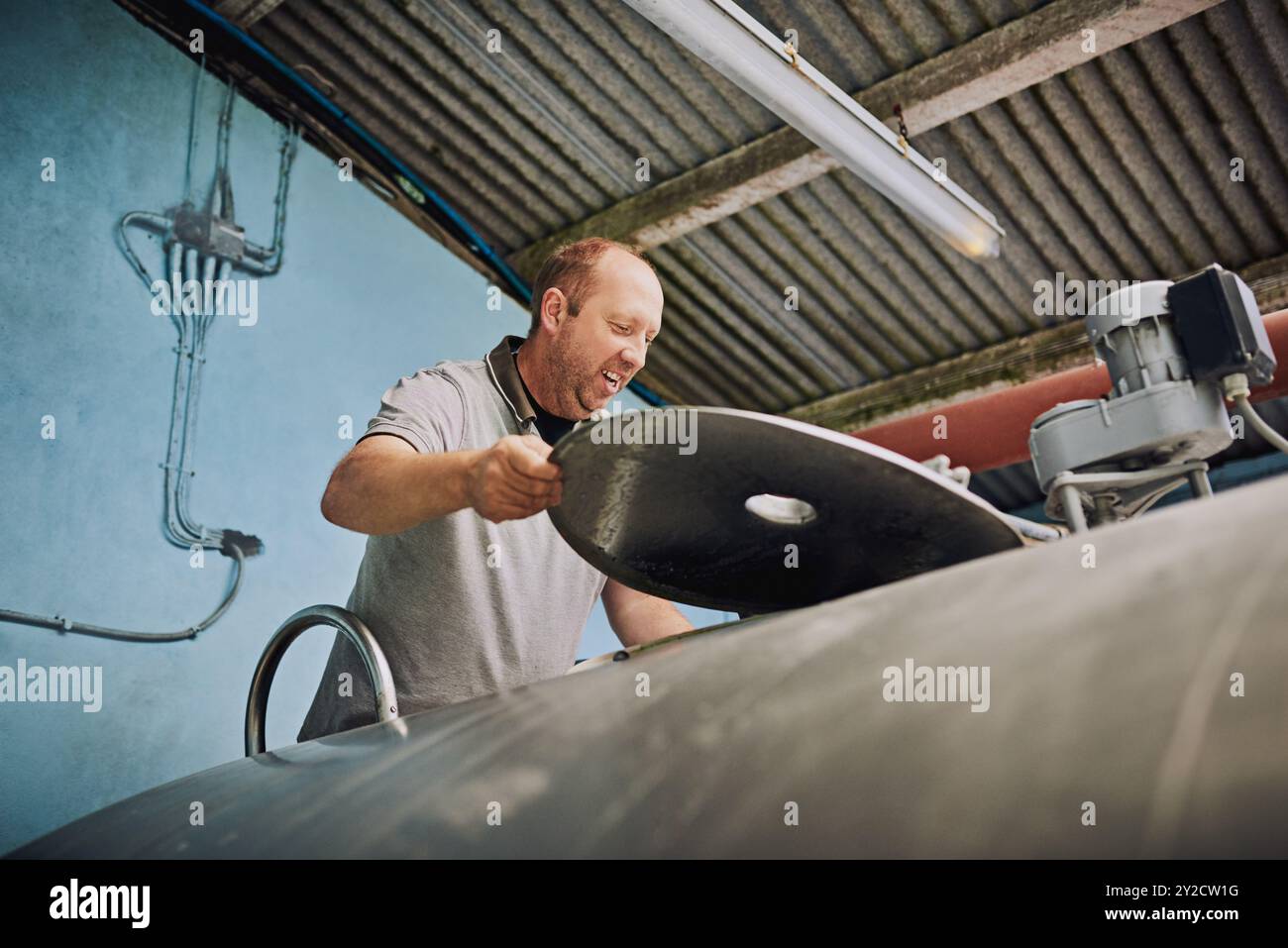 Farming, warehouse and man with machine for milk production, livestock ...
