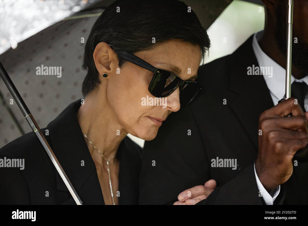Close up of grieving senior woman in black sunglasses standing by ...