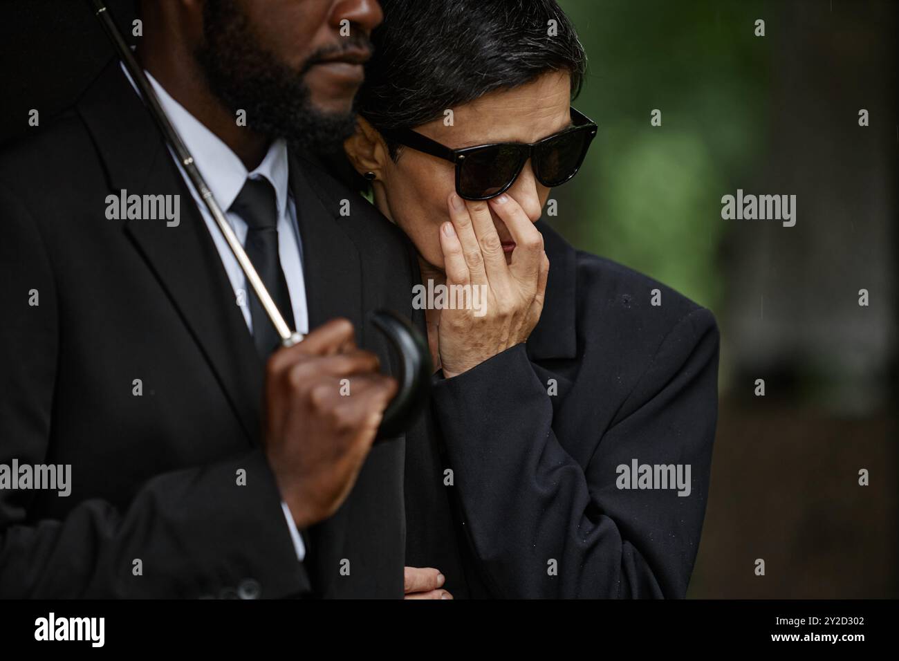 Medium shot of crying senior woman in black sunglasses wiping tears ...