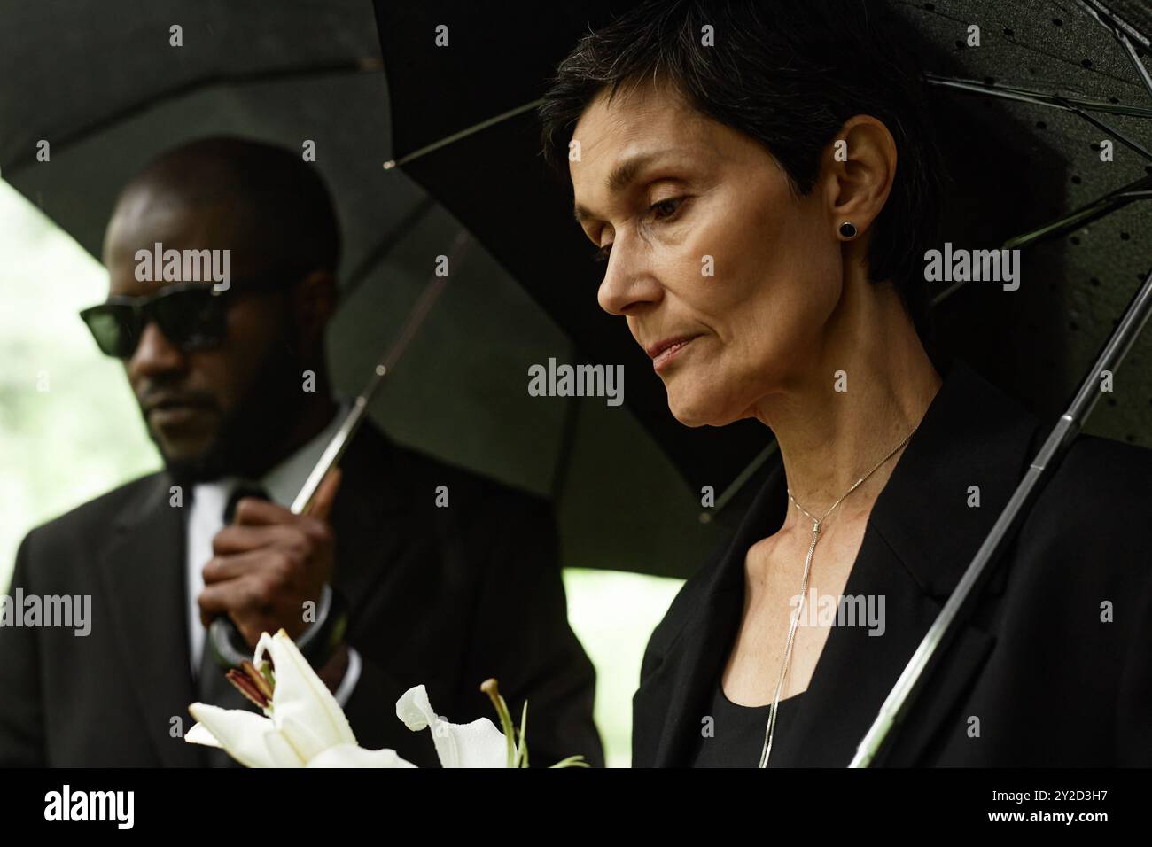 Side view of sorrowful senior woman looking down on grave grieving loss ...