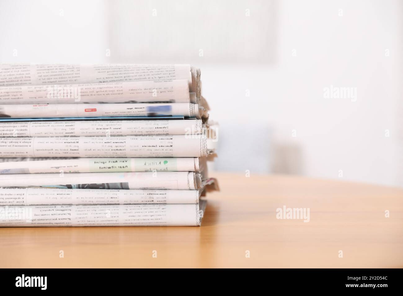 Stack of many newspapers in different languages on wooden table, space ...