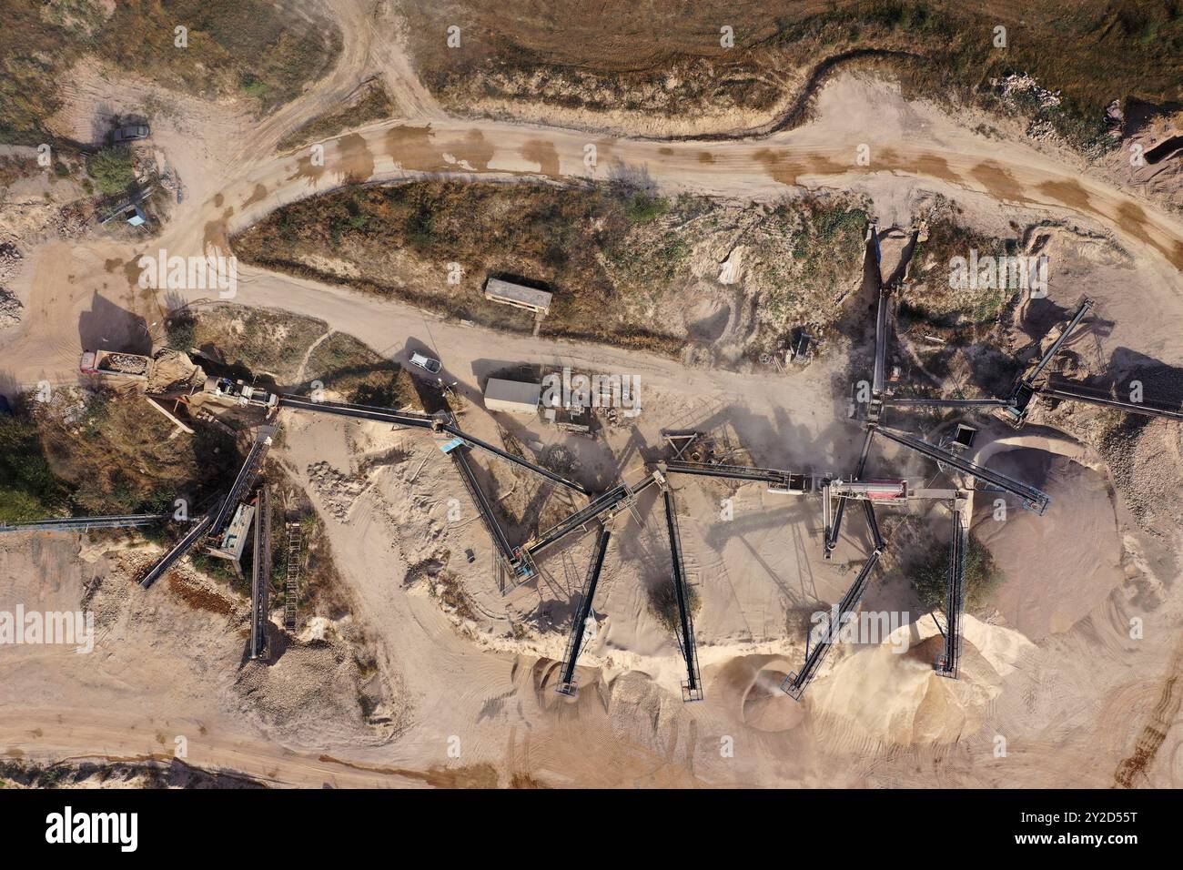 Aerial view of an excavator loading crushed stone into a dump truck in a crushed stone quarry ...