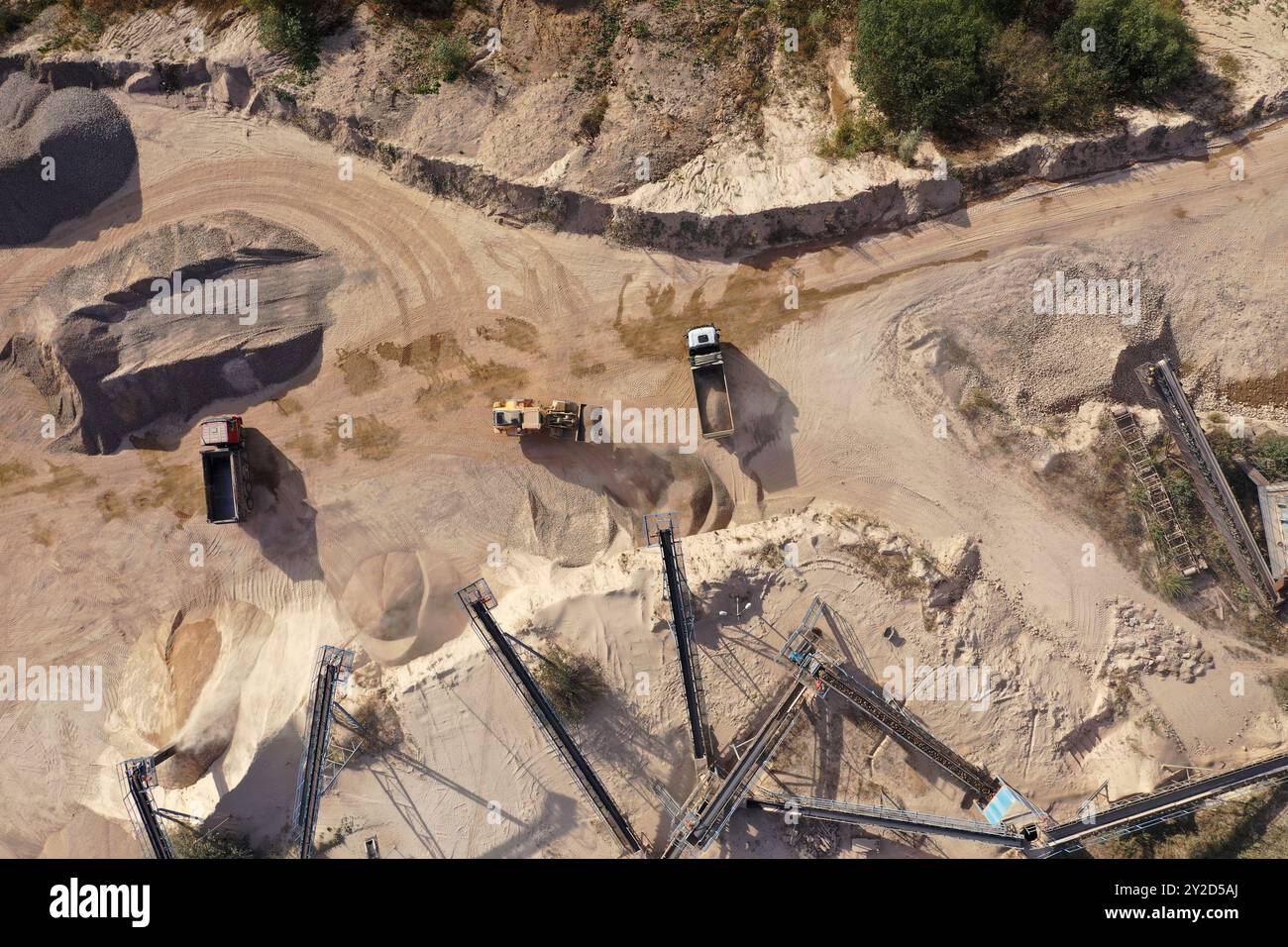 Aerial view of an excavator loading crushed stone into a dump truck in a crushed stone quarry ...