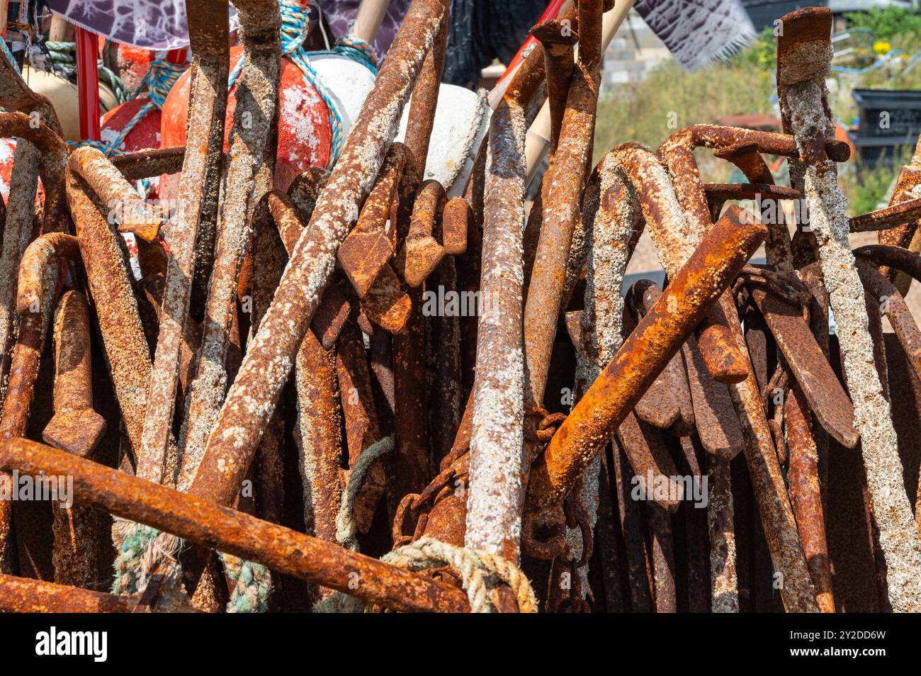 A stack of rusty steel anchors with ropes, chains and barnacles on the ...