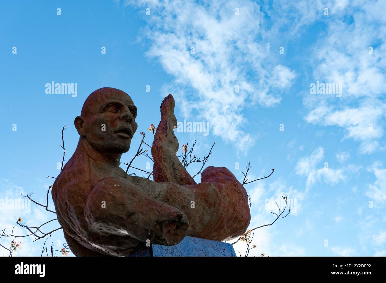 Powerful bronze sculpture of a muscular figure reaching upward, set ...