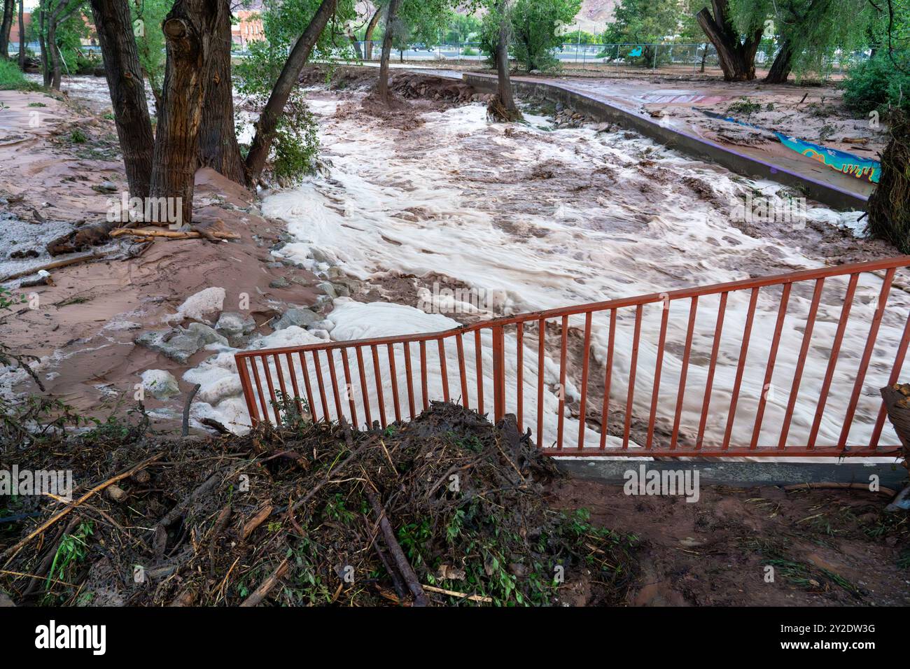 Debris on a street bridge from flash flooding after a summer rain storm ...