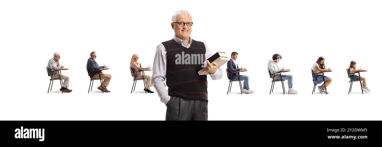 Mature male teacher holding books in front of people seated in school ...