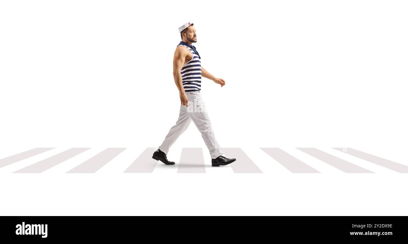 Full length profile shot of a sailor walking at a pedestrian crossing ...