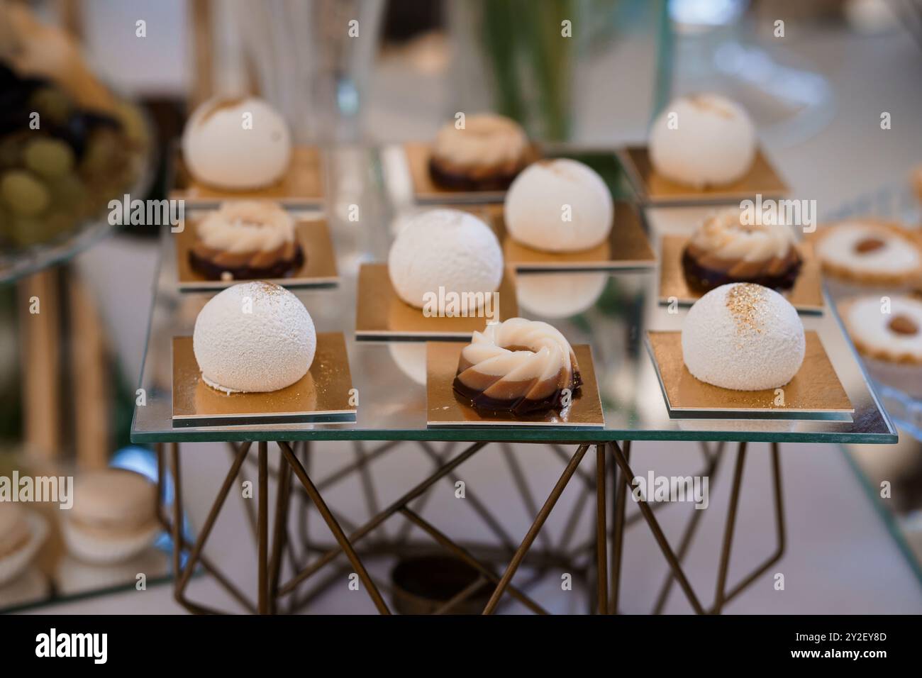 Elegant Display of Assorted Gourmet Desserts on a Modern Glass Stand Stock Photo - Alamy