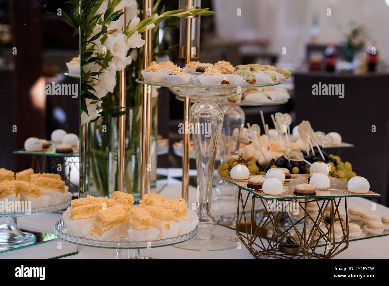 Elegant Dessert Buffet Display with Assorted Pastries and Floral Arrangement Stock Photo - Alamy